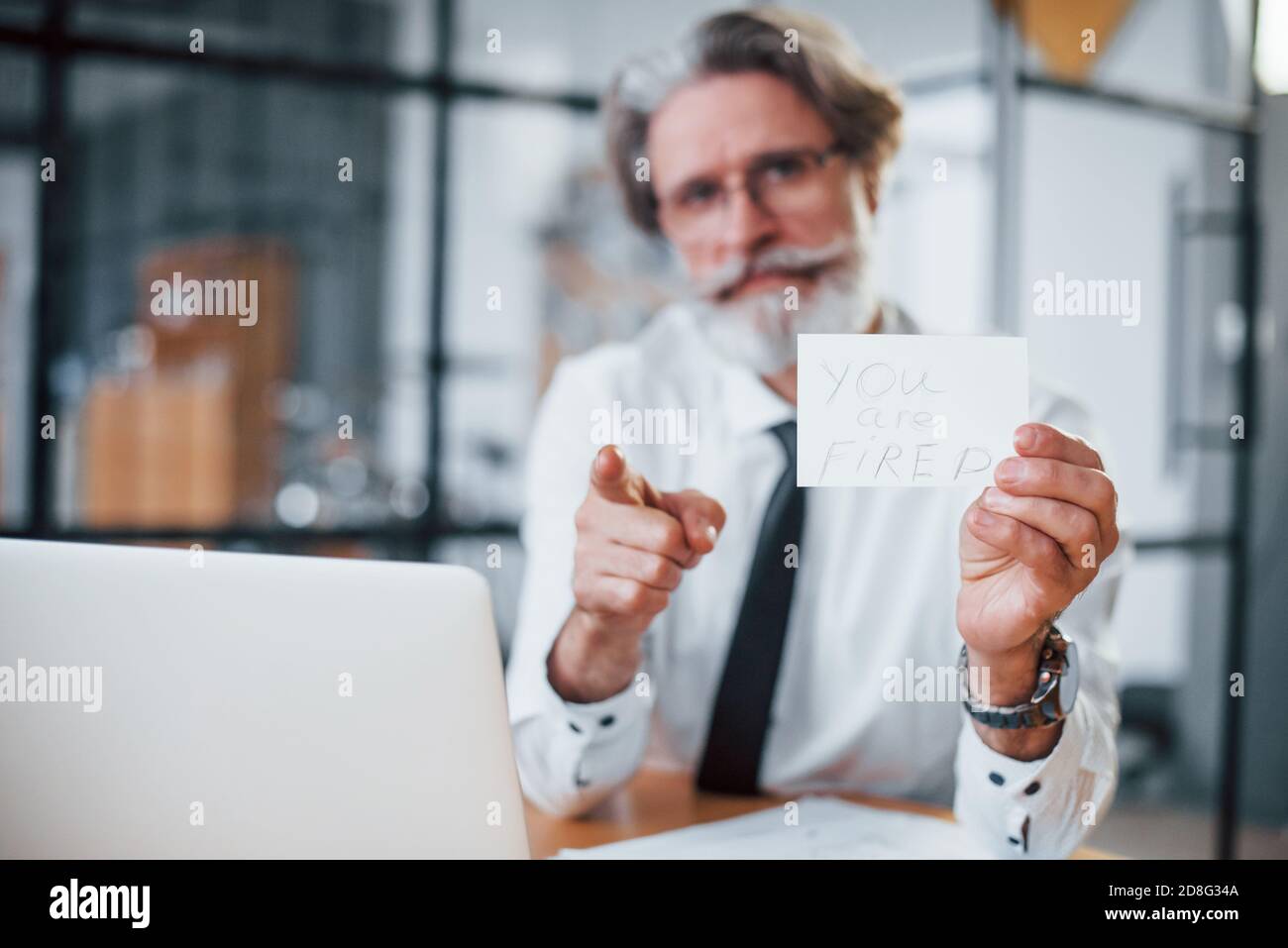 Holding paper with text you are fired. Mature businessman with grey ...