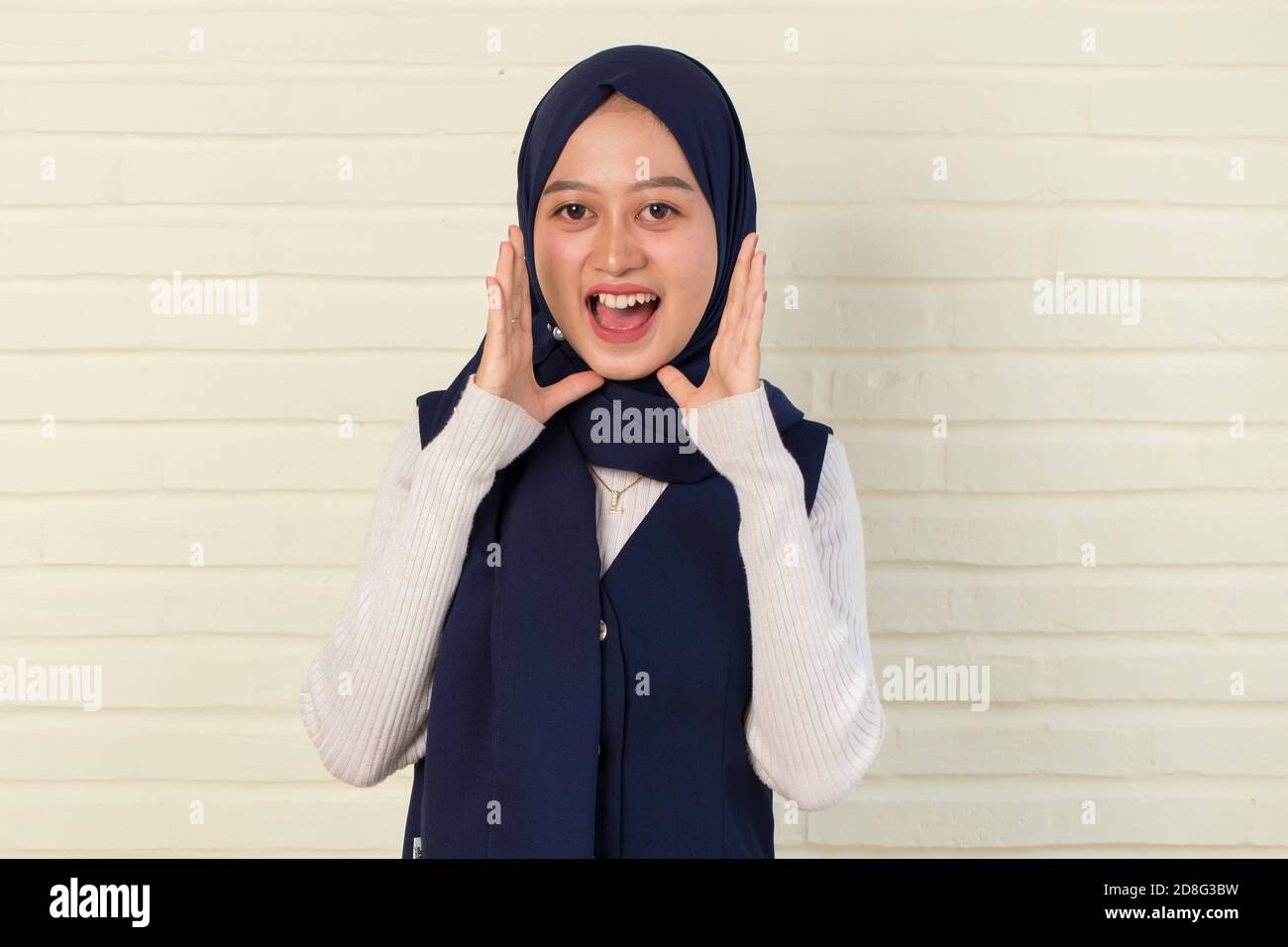Portrait of young Asian muslim woman wearing hijab shouting and yelling ...