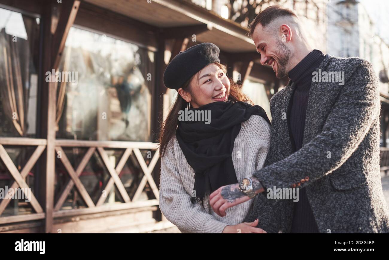 Lovely multiracial couple have a walk in the city and embracing each ...