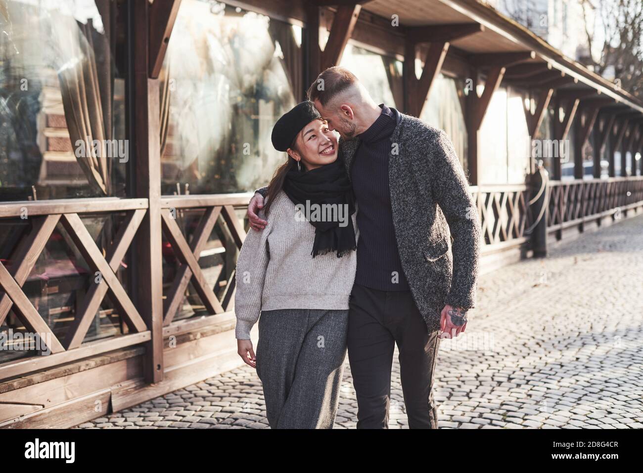 Lovely multiracial couple have a walk in the city and embracing each ...