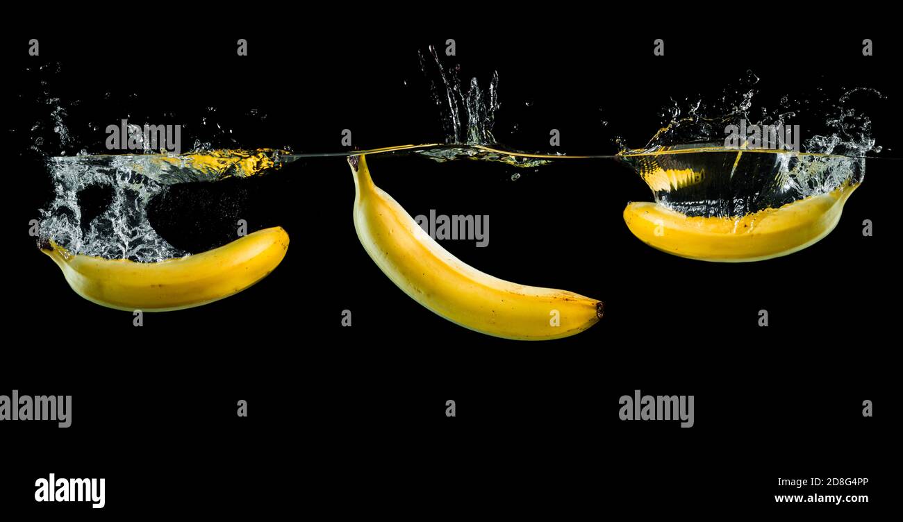 banana splash in water at black background Stock Photo - Alamy