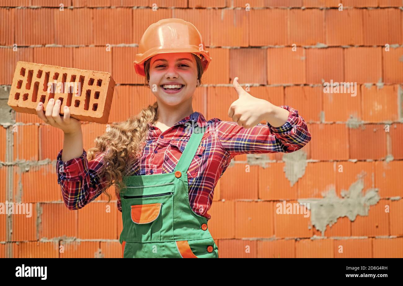 Little worker in helmet building from brick. Architecture construction ...