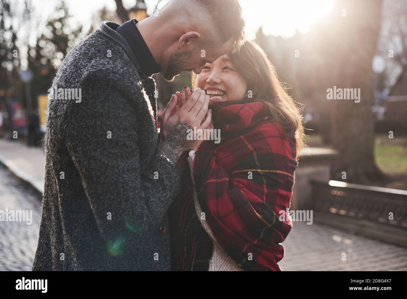 Beautiful sunlight. Happy multiracial couple together outdoors in the ...