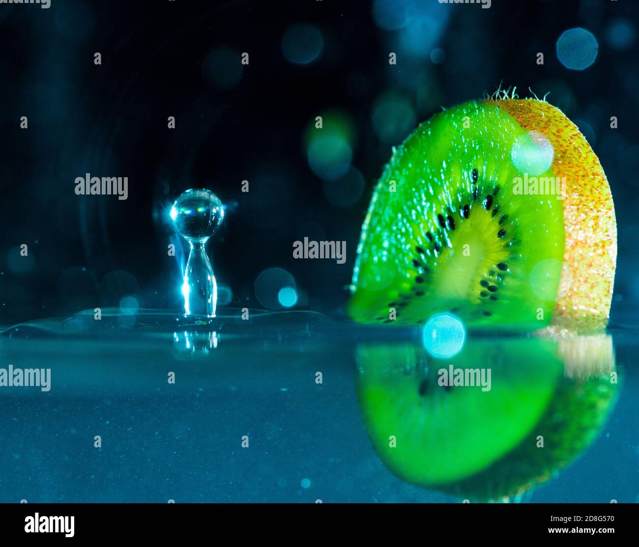 fresh kiwi fruits splash in water on black background Stock Photo - Alamy