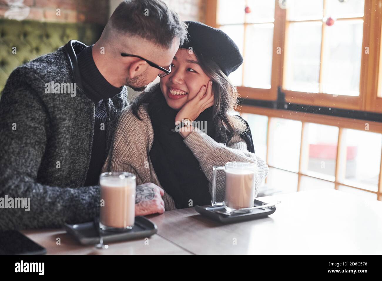 Multiracial couple talking in cafe. Asian girl with her caucasian ...