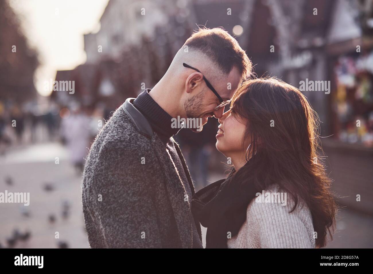 Happy multiracial couple together outdoors in the city. Asian girl with ...