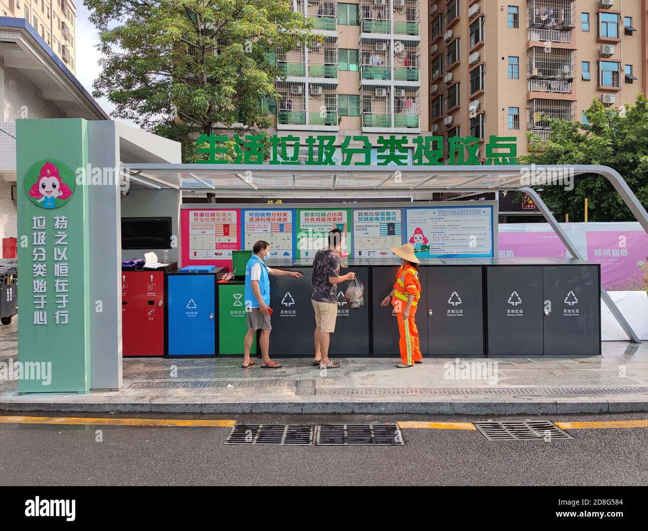 Cleaning staff guide a person sorting garbage at a garbage ...