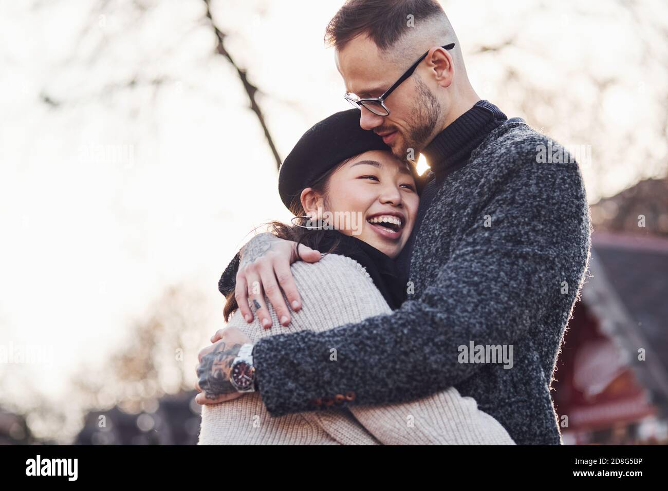 Happy multiracial couple together outdoors in the city. Asian girl with ...