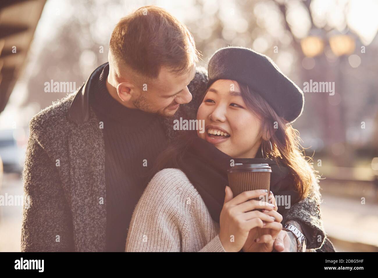 Happy multiracial couple together outdoors in the city. Asian girl with ...