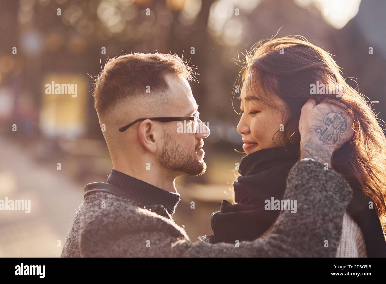 Beautiful sunlight. Happy multiracial couple together outdoors in the ...