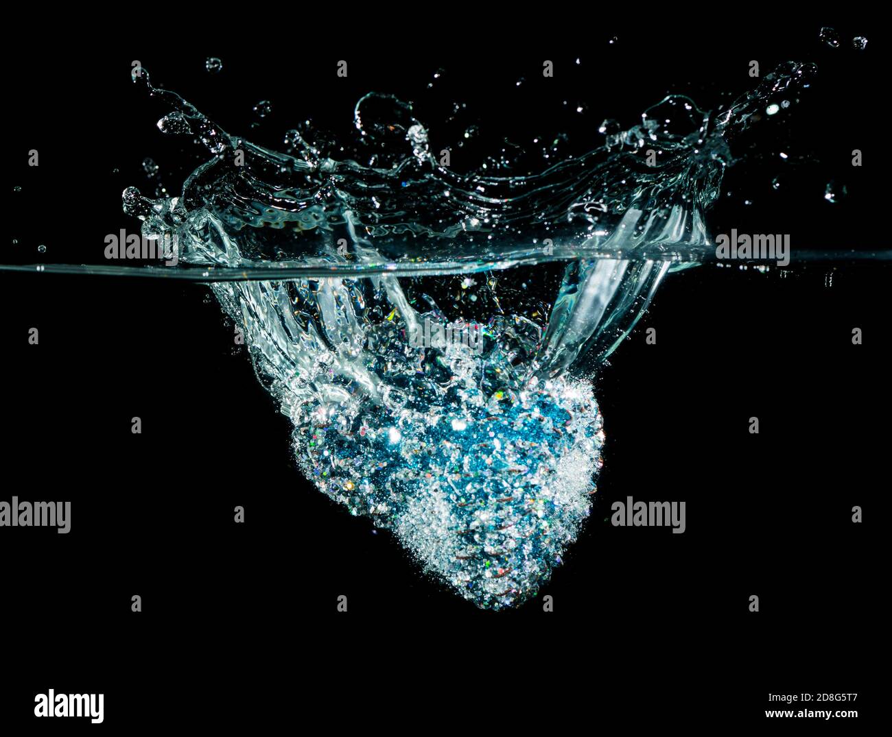 colorful holiday snowflakes splash in water at black background Stock ...