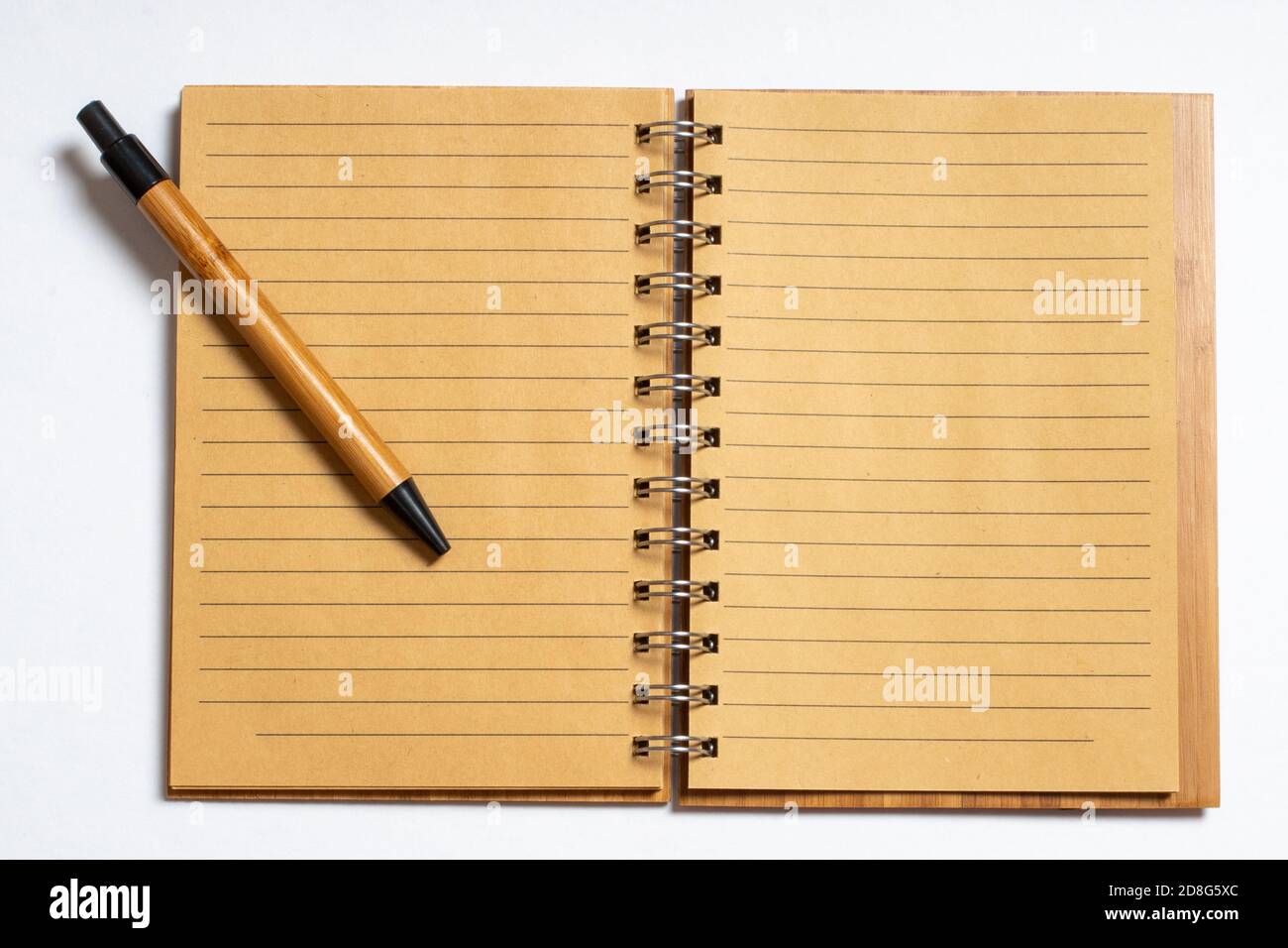 Top view of an open notebook with a pen or pencil on a white background ...