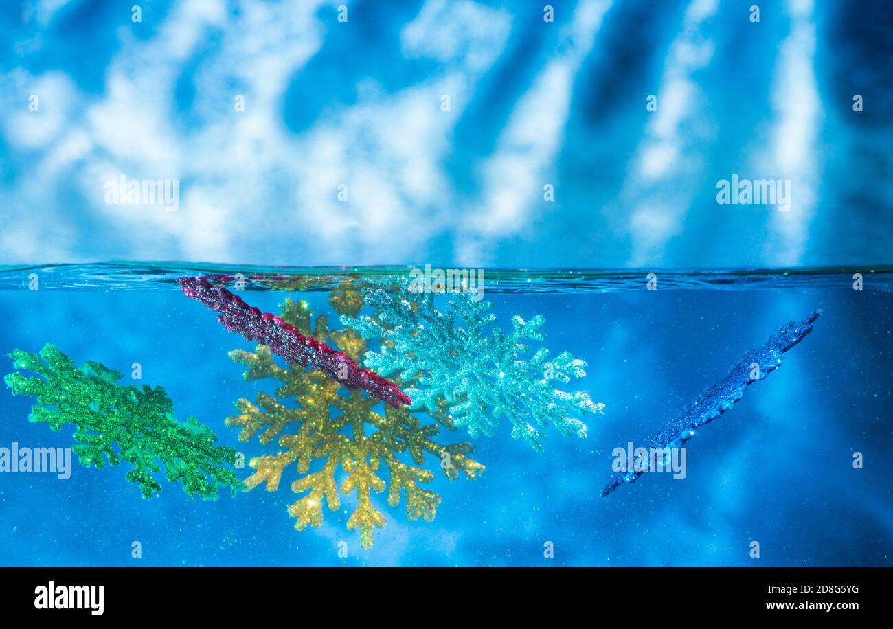 colorful holiday snowflakes splash in water at black background Stock ...