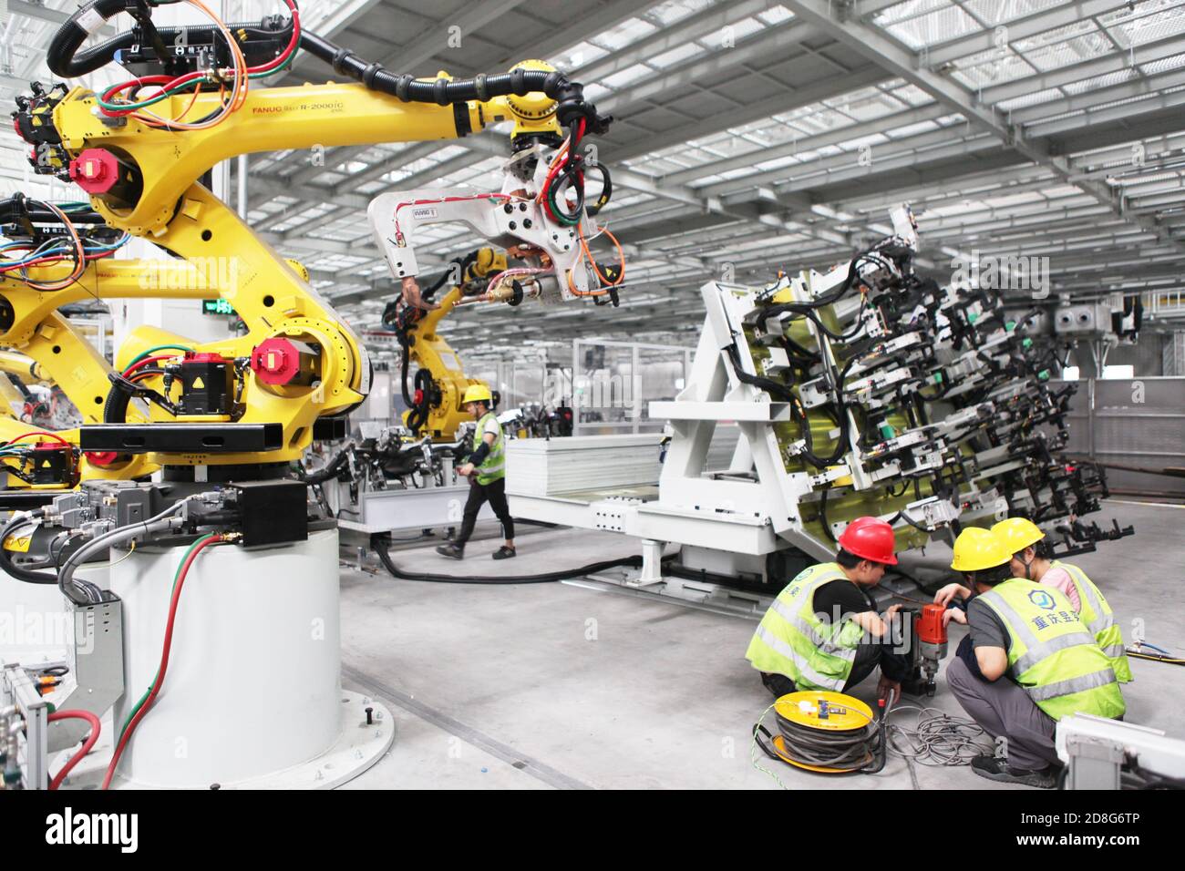 Staff work to examine robotic arms along the production line of Wey ...