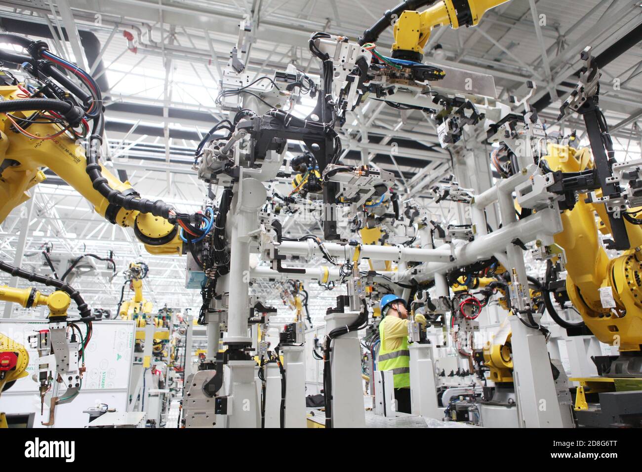 Staff work to examine robotic arms along the production line of Wey ...