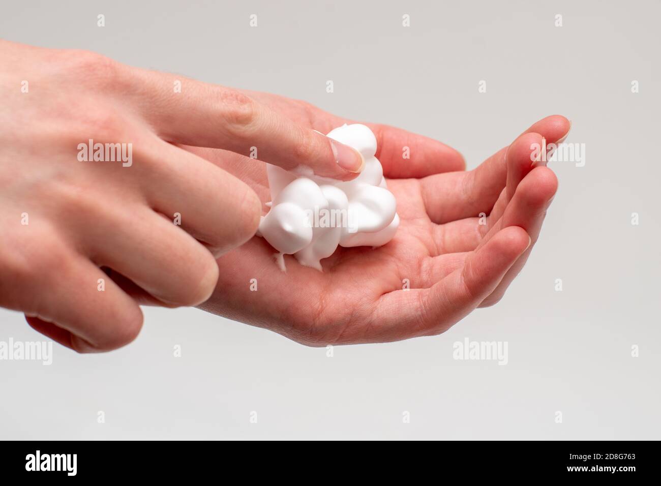 close up foam in two hands, isolated on white background, palm touch ...