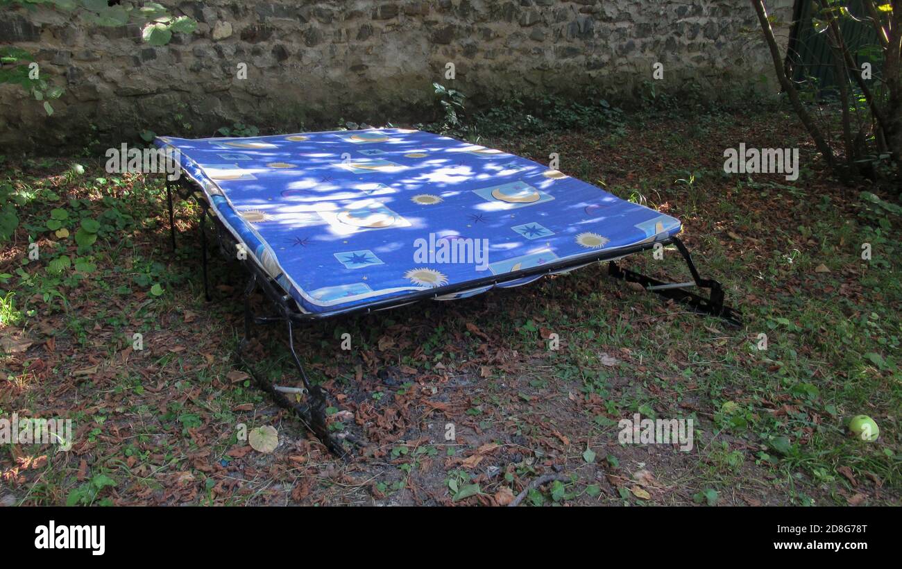 A bed in the green garden under the trees Stock Photo - Alamy
