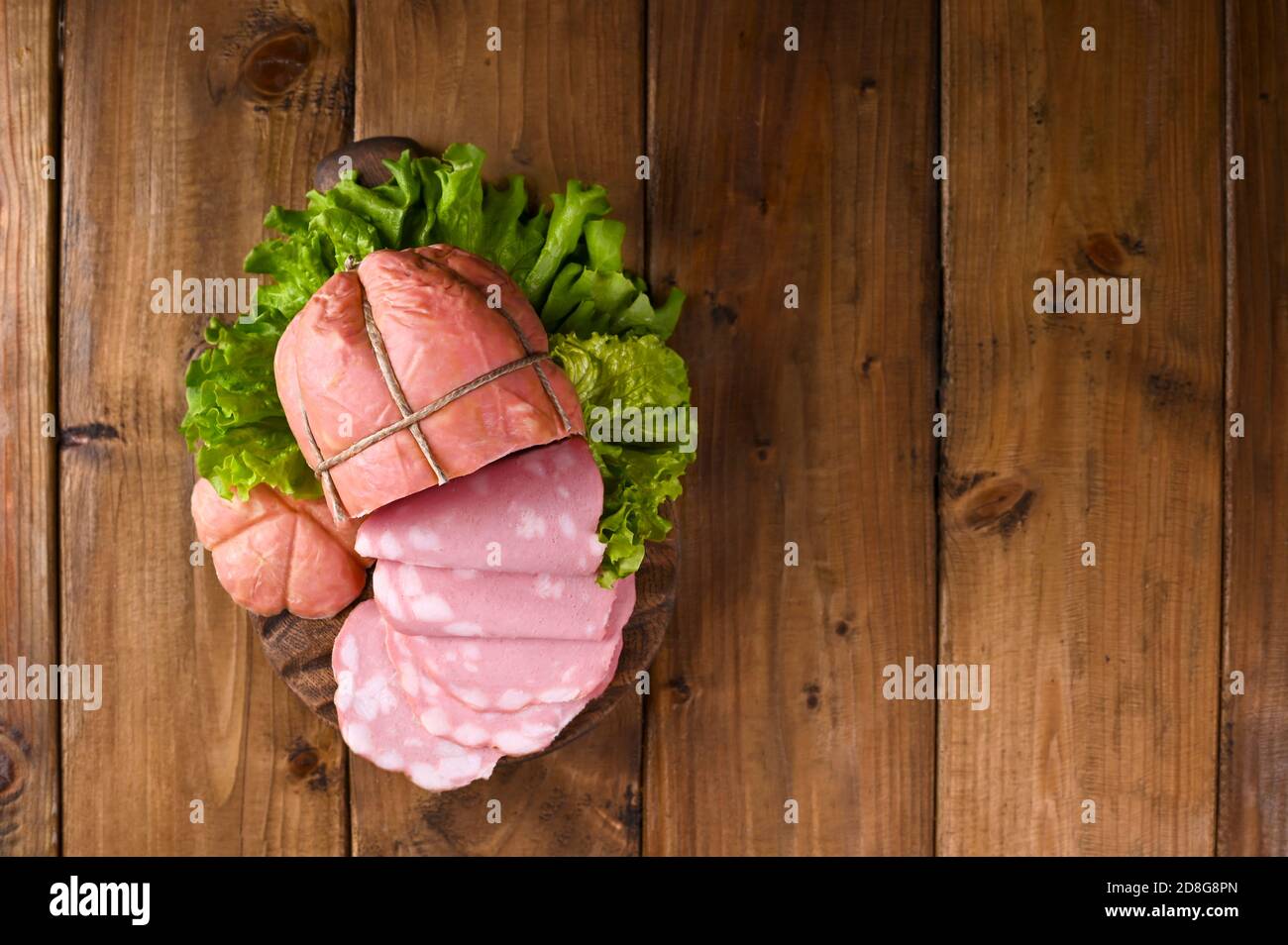 Italian Whole block of mortadella on a wooden plate. Traditional big ...