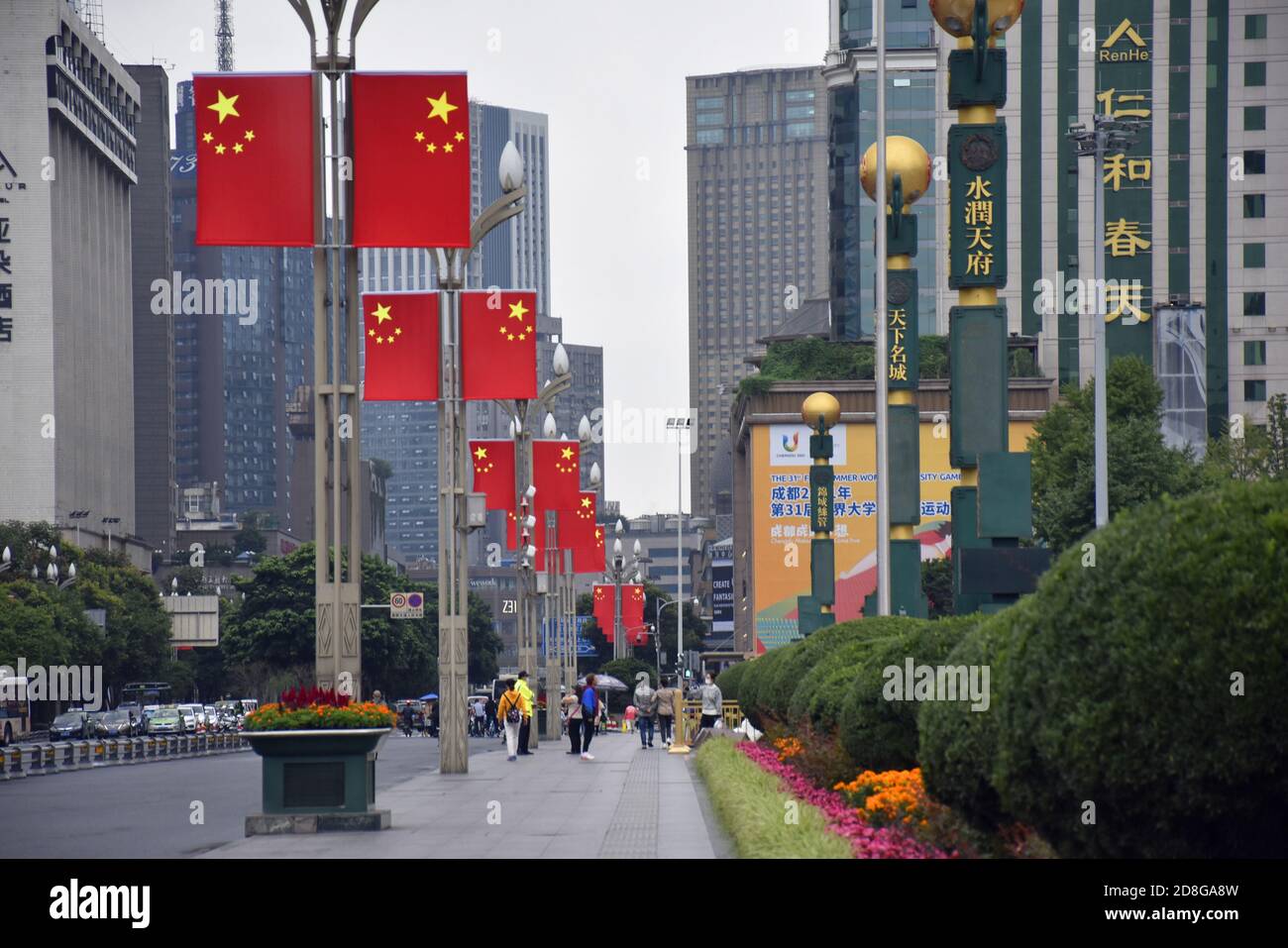 National flags fly on the street, under which vehicles and pedestrians ...