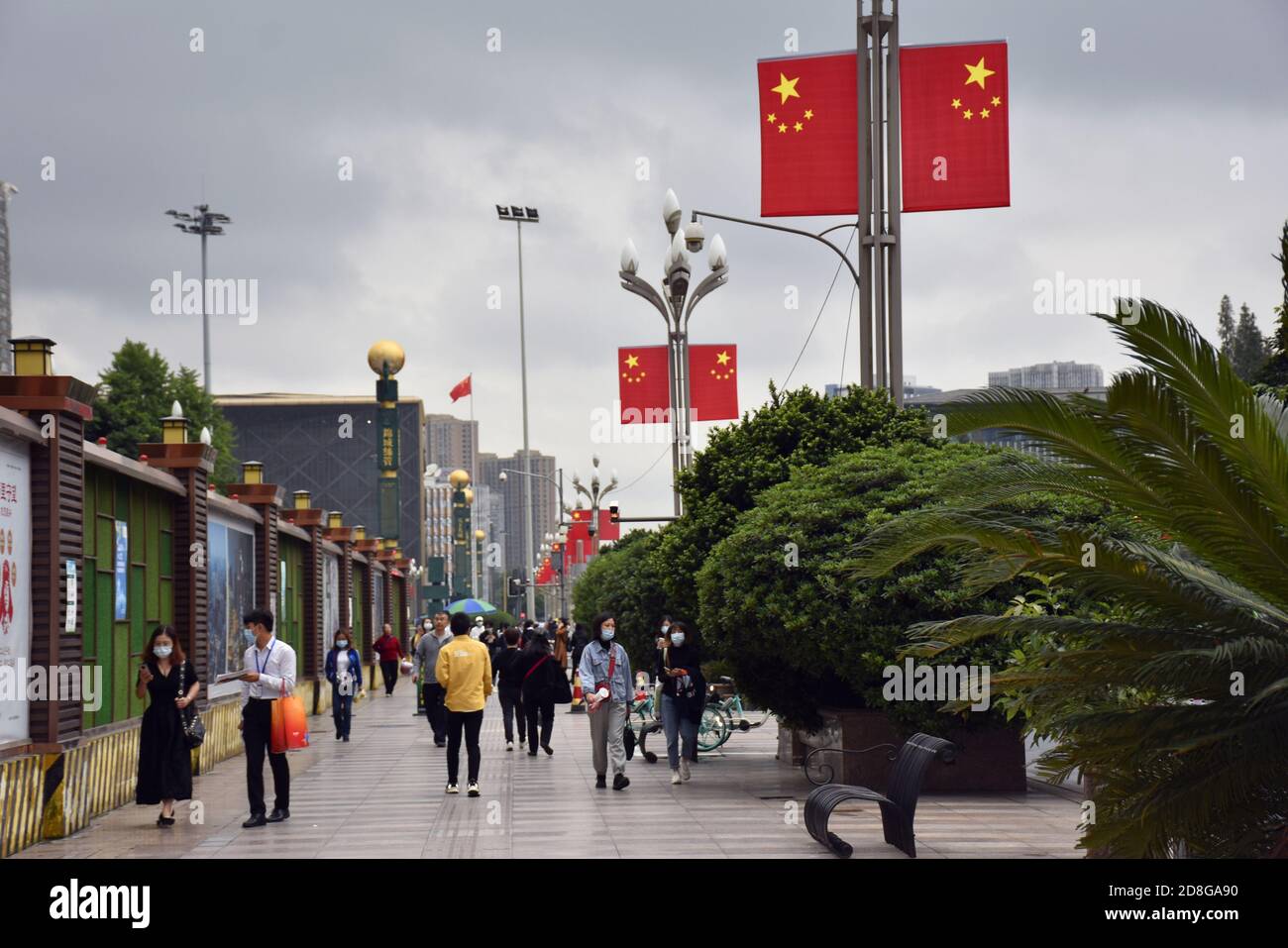 National flags fly on the street, under which vehicles and pedestrians ...