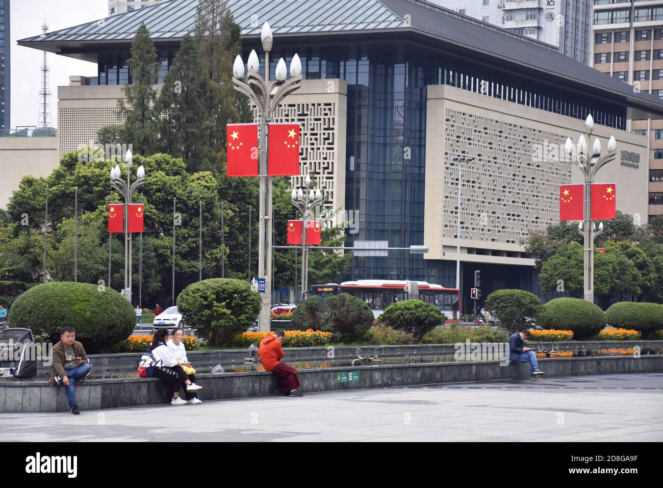 National flags fly on the street, under which vehicles and pedestrians ...