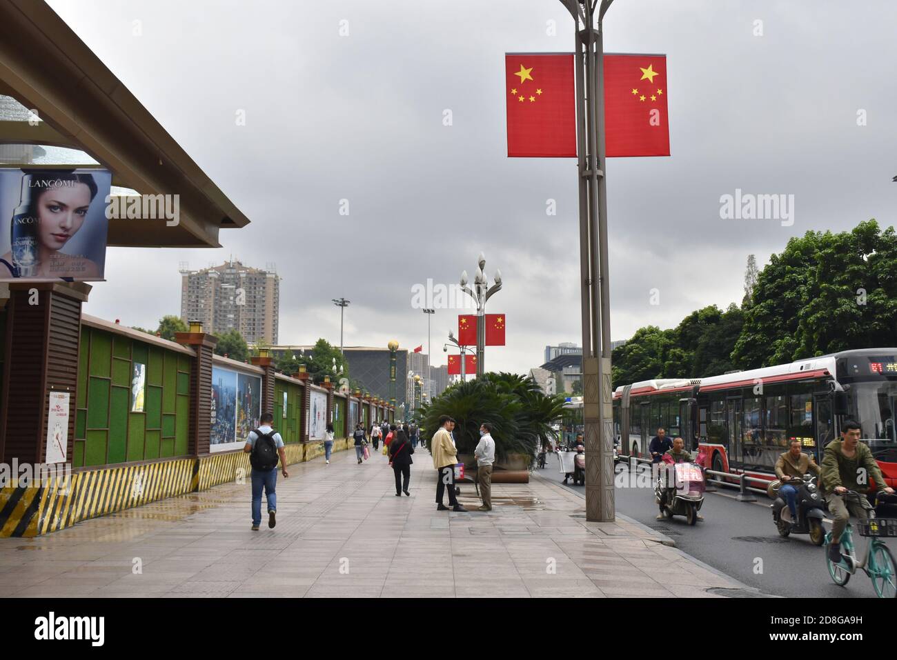 National flags fly on the street, under which vehicles and pedestrians ...