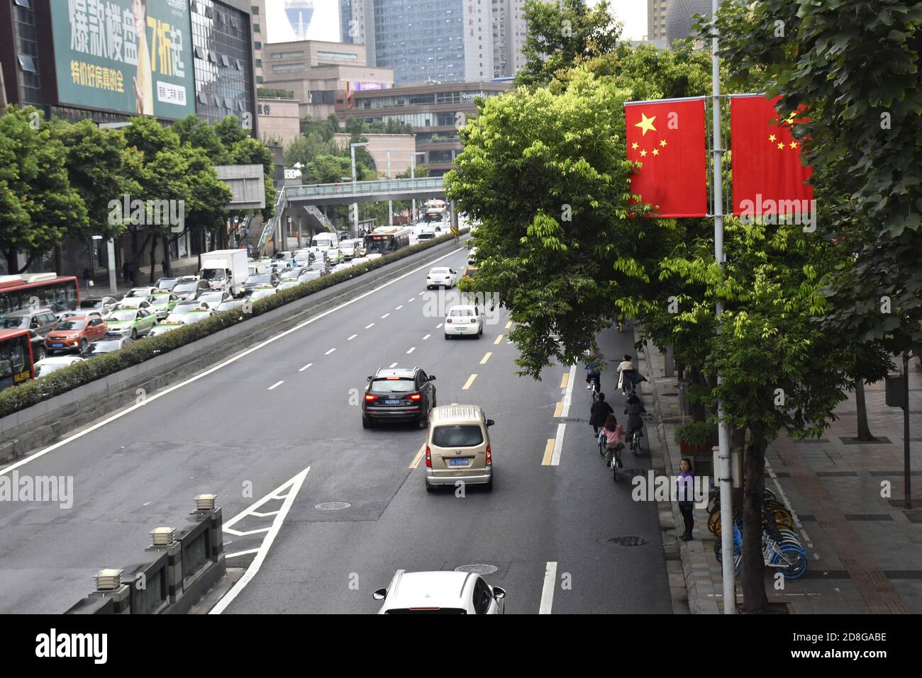 National flags fly on the street, under which vehicles and pedestrians ...