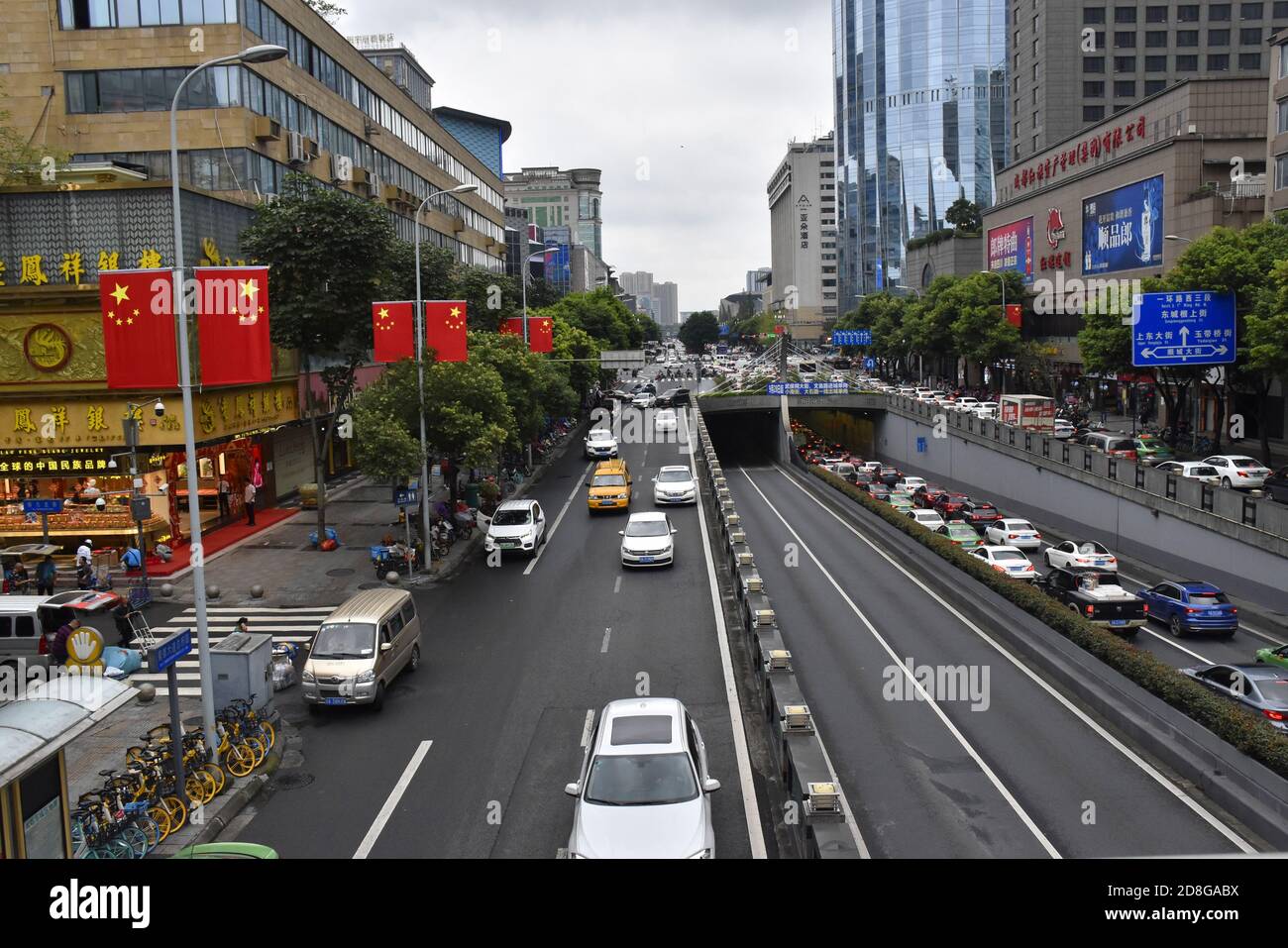 National flags fly on the street, under which vehicles and pedestrians ...