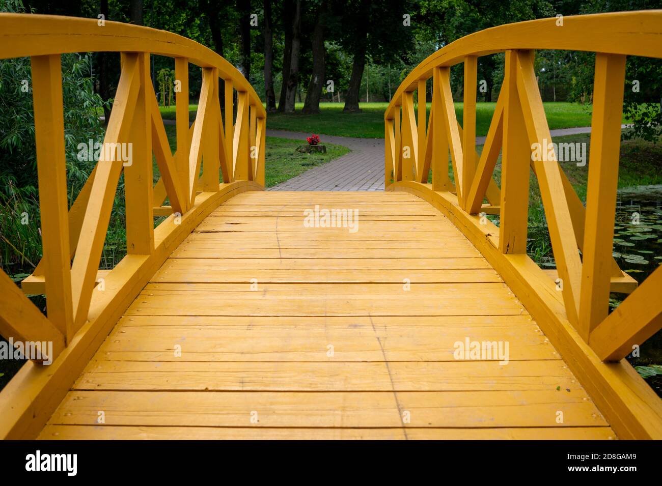 Empty arched wooden pedestrian bridge curving away in a receding ...