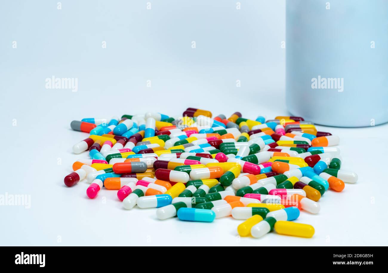 Colorful capsule pills near plastic drug bottle. Multi-colored capsule ...