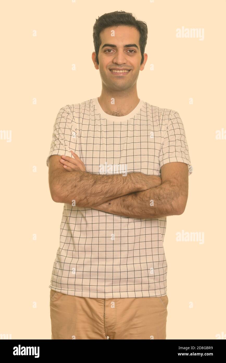 Portrait of happy young Persian man smiling with arms crossed Stock ...