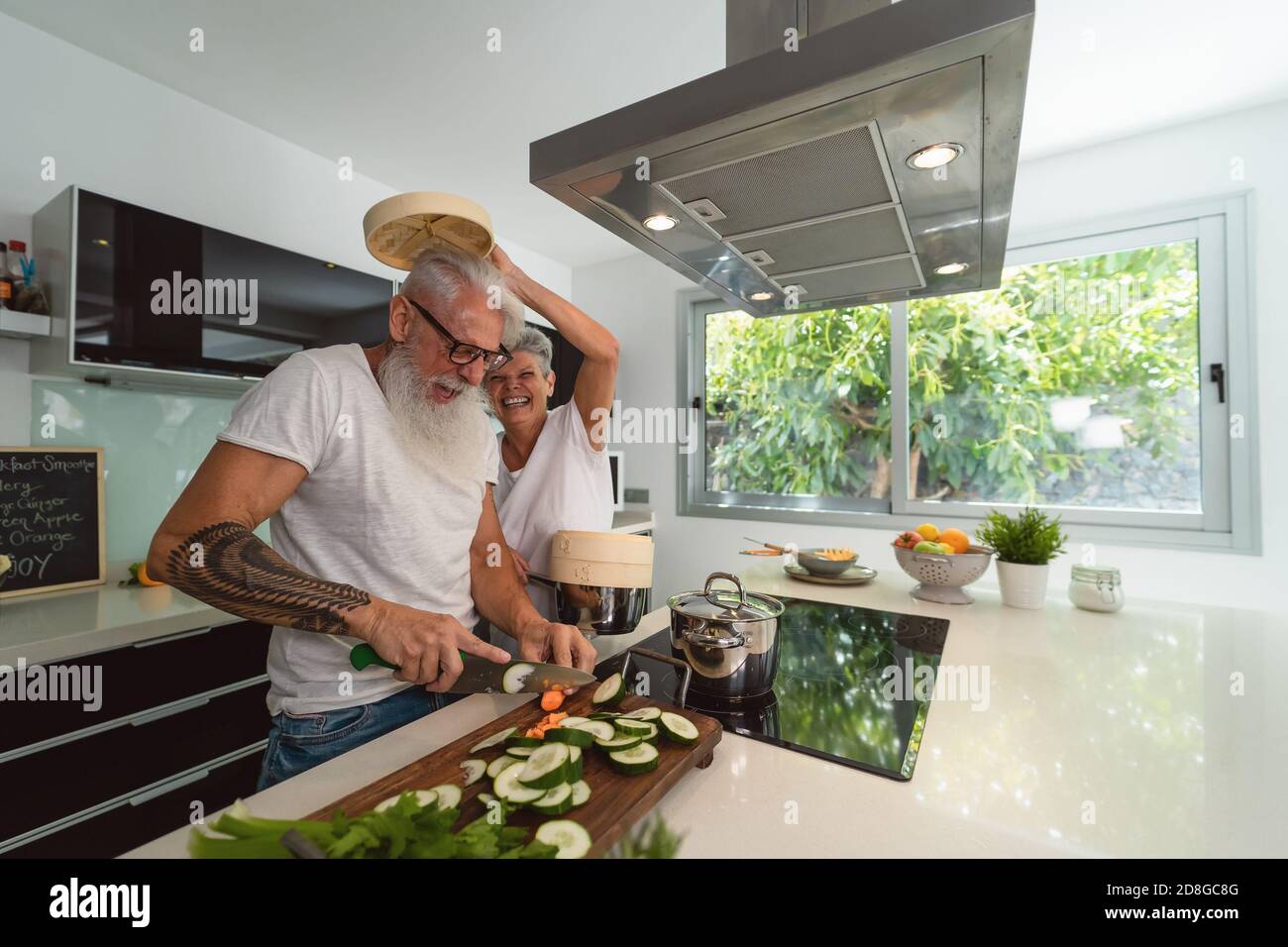 Happy senior couple having fun cooking together at home - Elderly ...