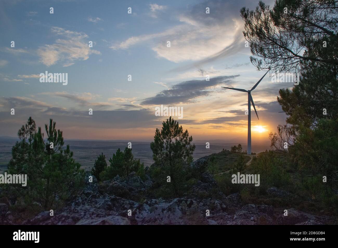 Windmill surrounded by greenery and hills under a cloudy sky in the ...