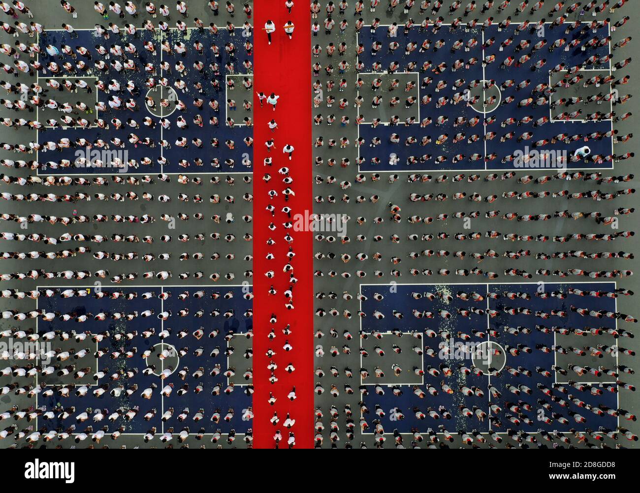 An aerial view of students arraying on the playground, attending a ...