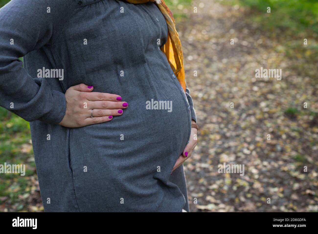 Close up picture of pregnant belly bump in third trimester outdoor in ...