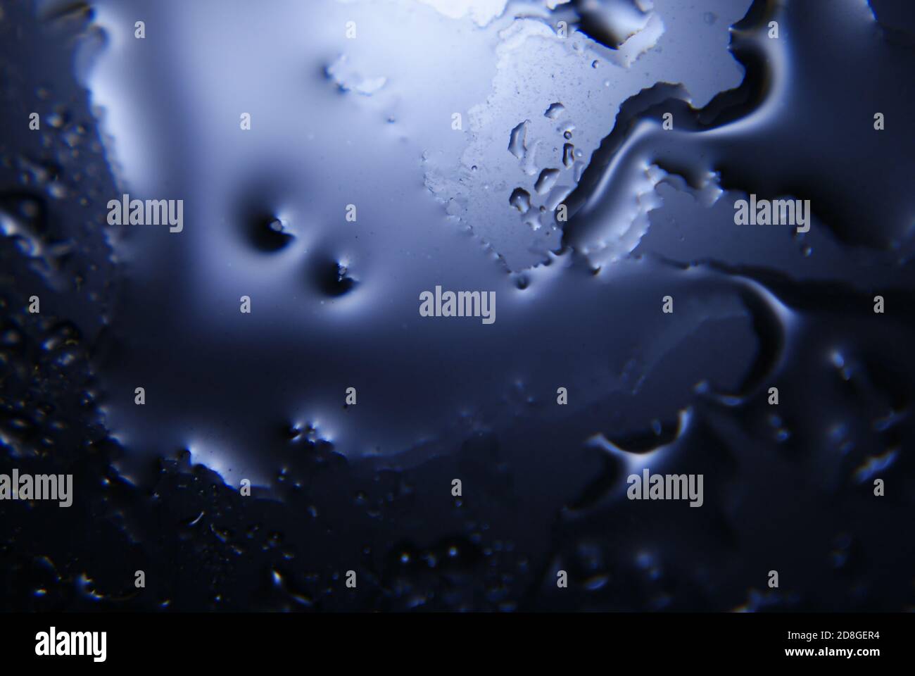 Glass surface with splashed water reflecting Stock Photo - Alamy