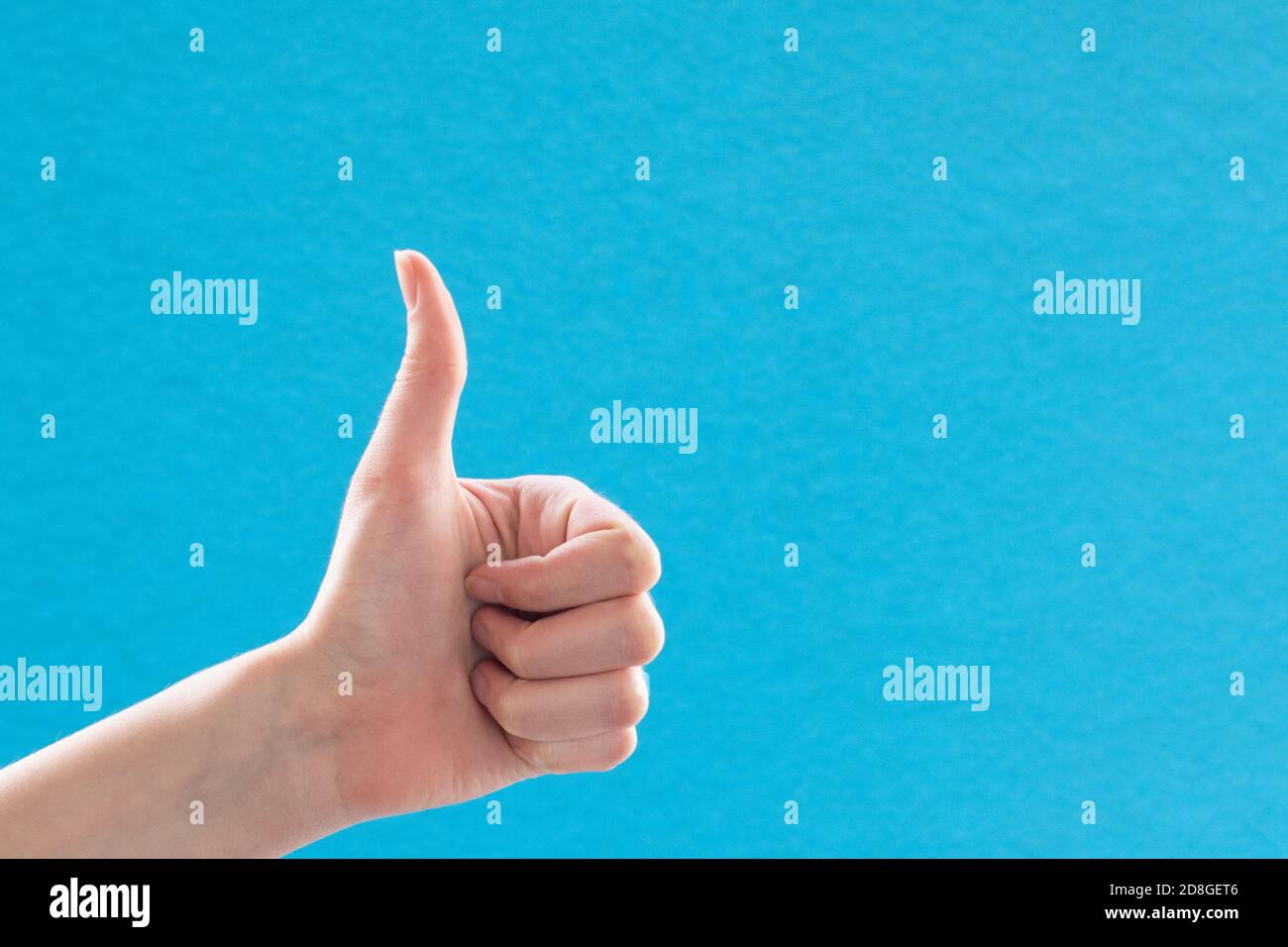 Close-up female hand holding thumb up hand sign. Positive hand gesture ...