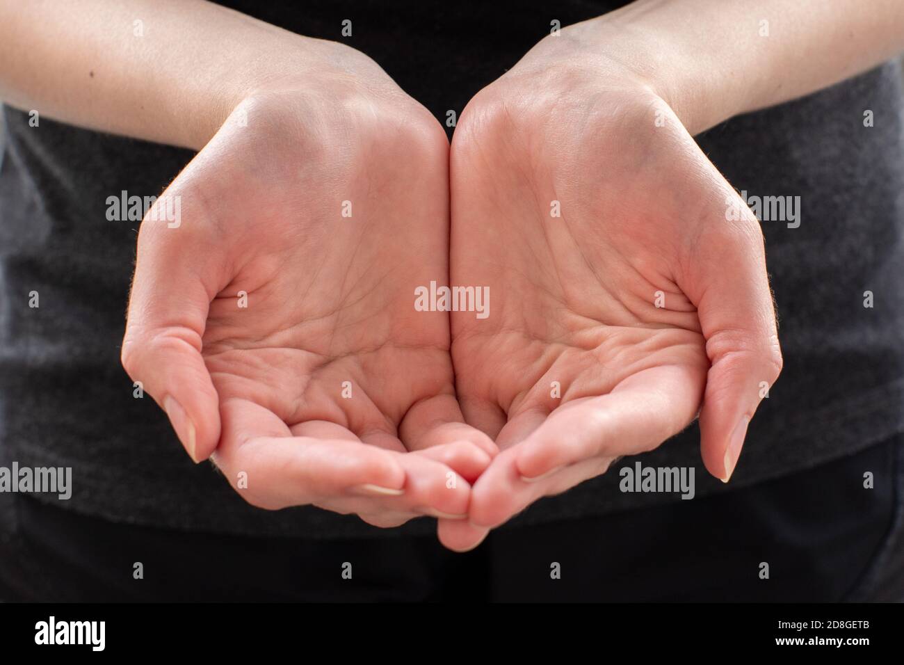 Close-up outstretched cup-shaped hands of a young woman, empty hands ...
