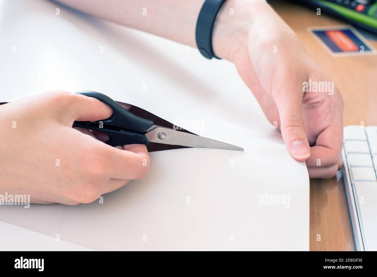 Close-up female hand cuts white paper with scissors. Creativity concept ...