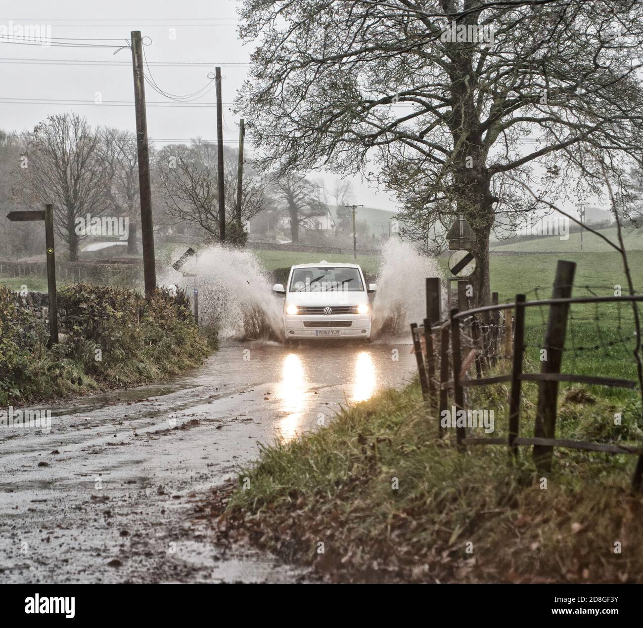 A van causing a splash going through a puddle Stock Photo - Alamy