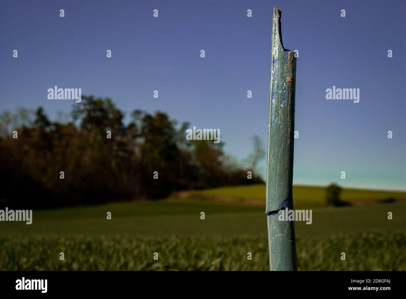 Wooden broken pole in field under blue skhy Stock Photo - Alamy
