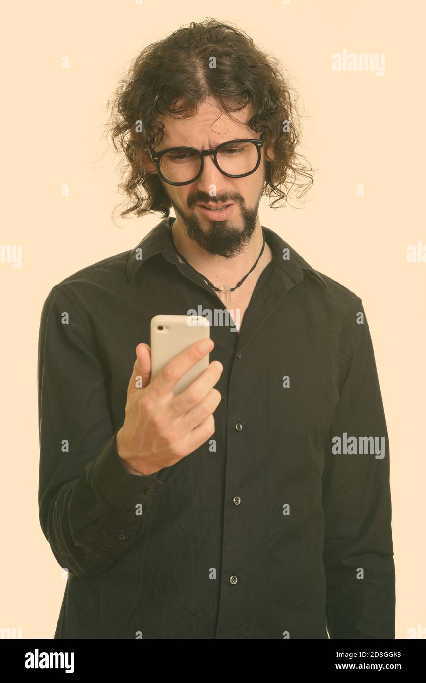 Handsome Caucasian man holding mobile phone looking upset Stock Photo ...