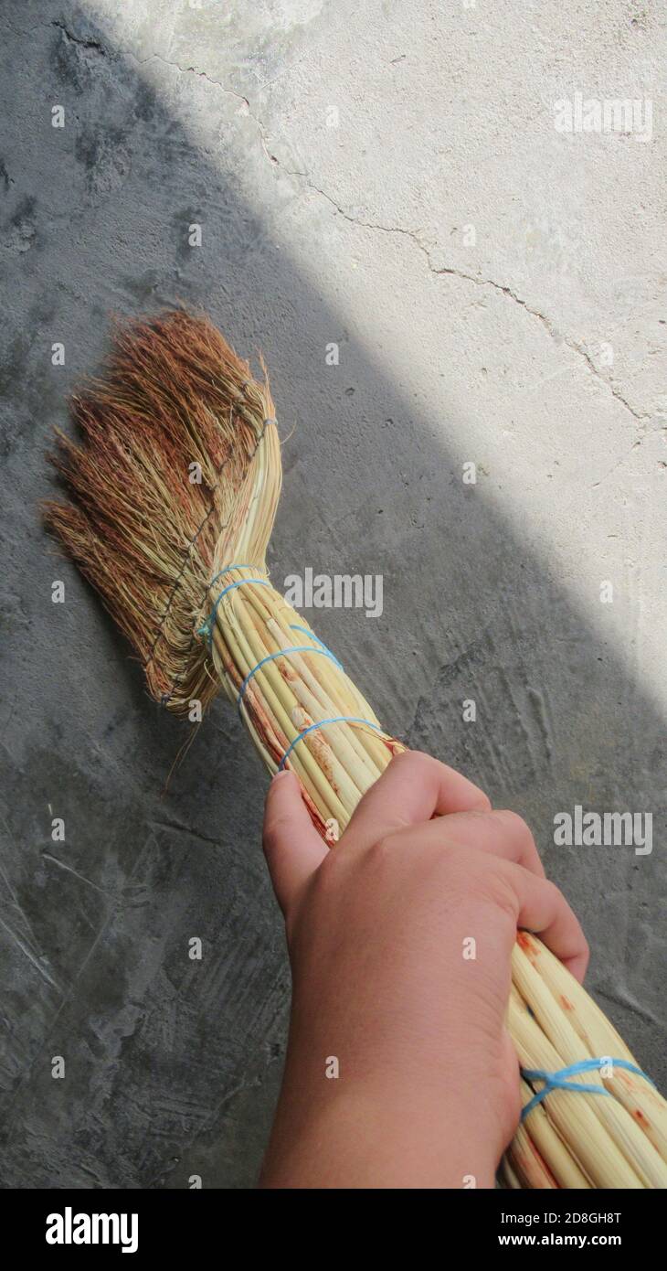 Male hand holding a sweep for cleaning his backyard Stock Photo - Alamy