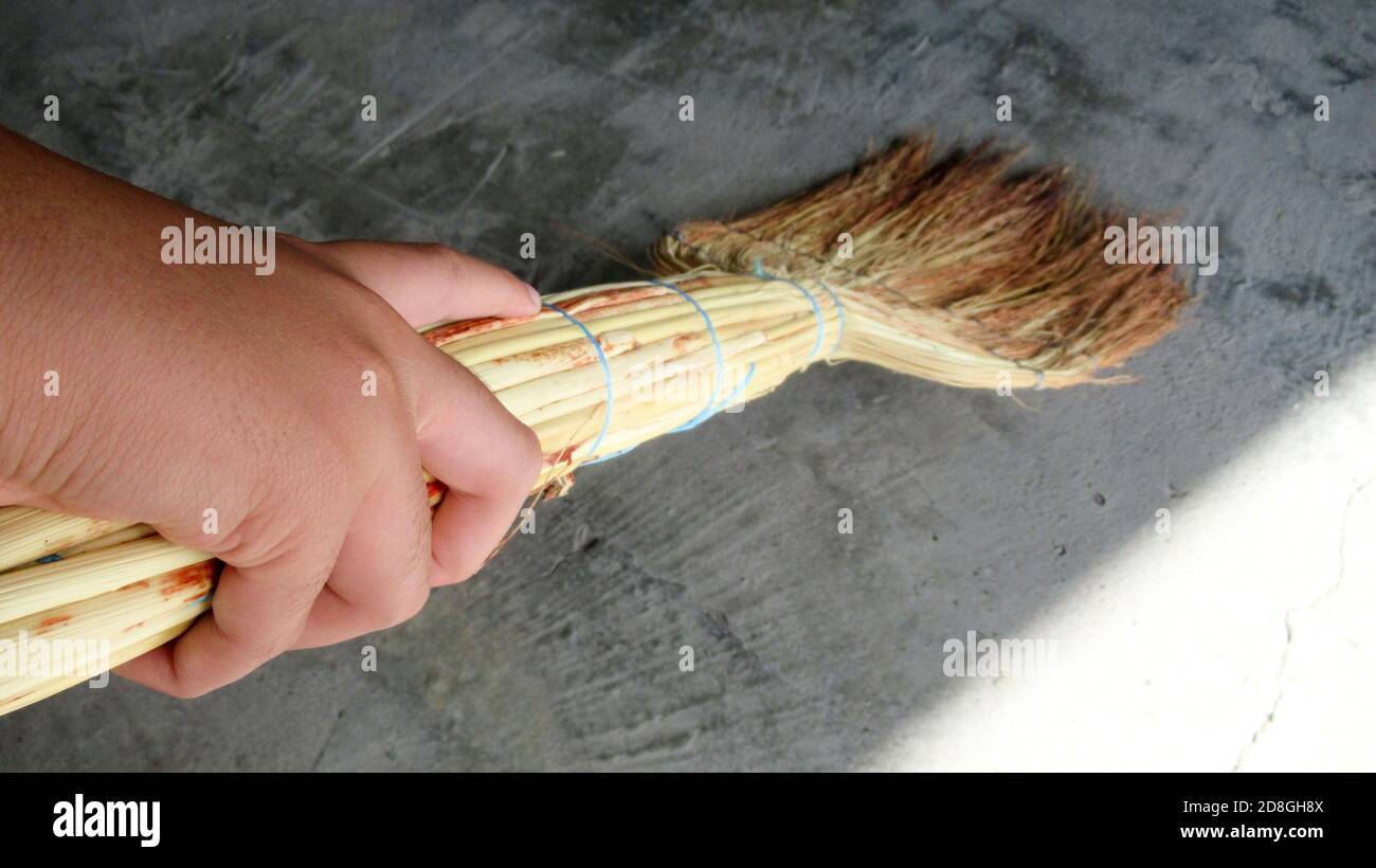 Male hand holding a sweep for cleaning his backyard Stock Photo - Alamy