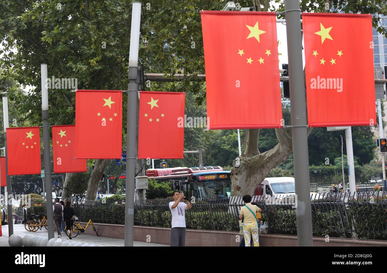 National flags of China are hung in the street light, welcoming the ...