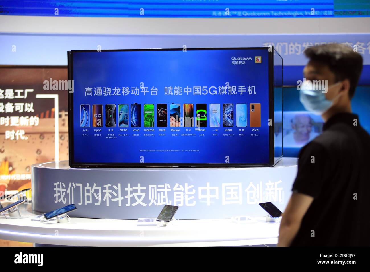 In this unlocated photo, visitors gather at the booth of Qualcomm, an ...