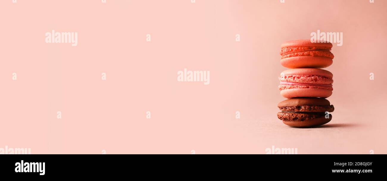 Pink and brown french dessert macaroons on a pastel pink background ...