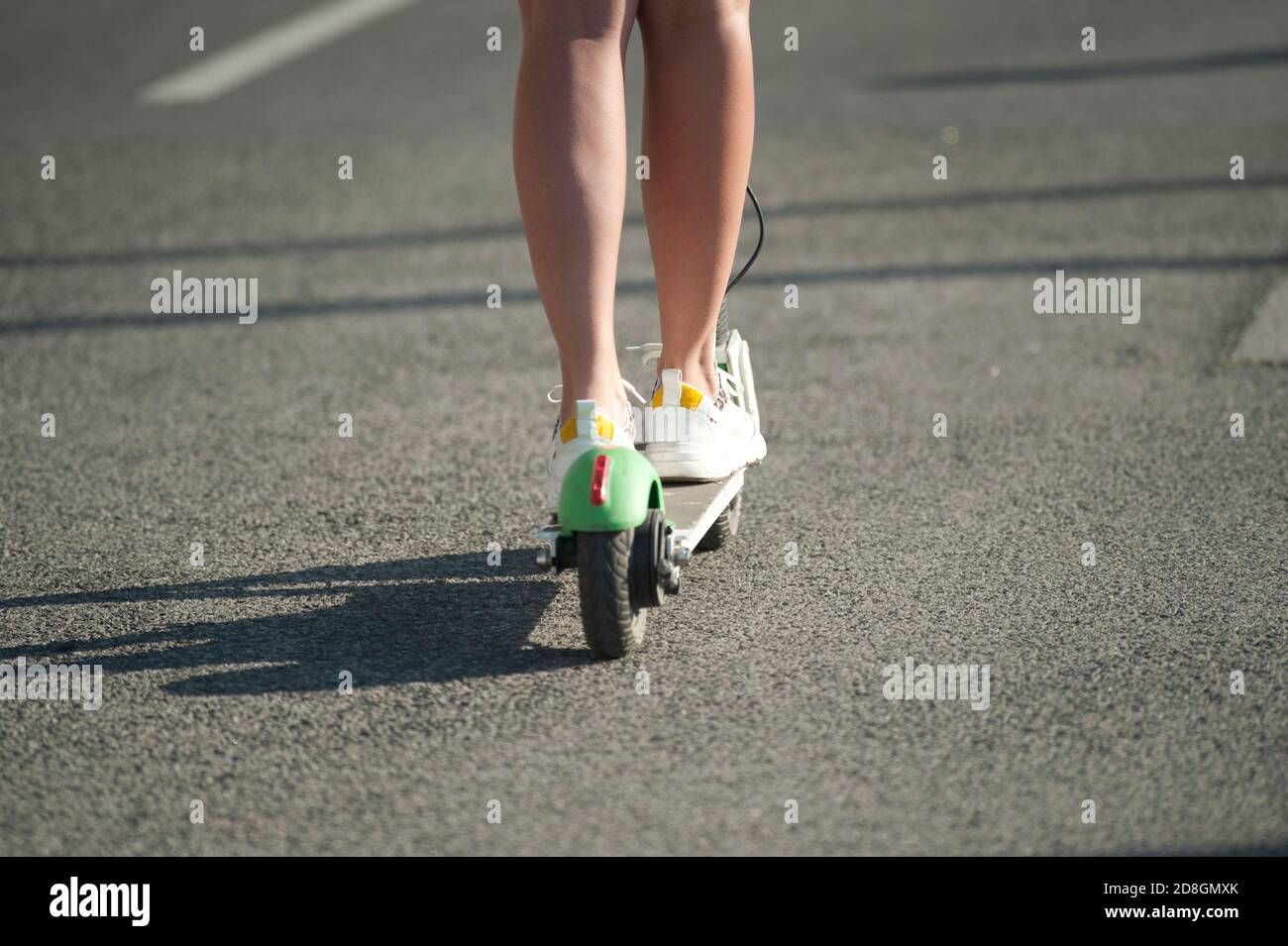 legs of boy riding electric scooter on the asphalt of the road Stock ...