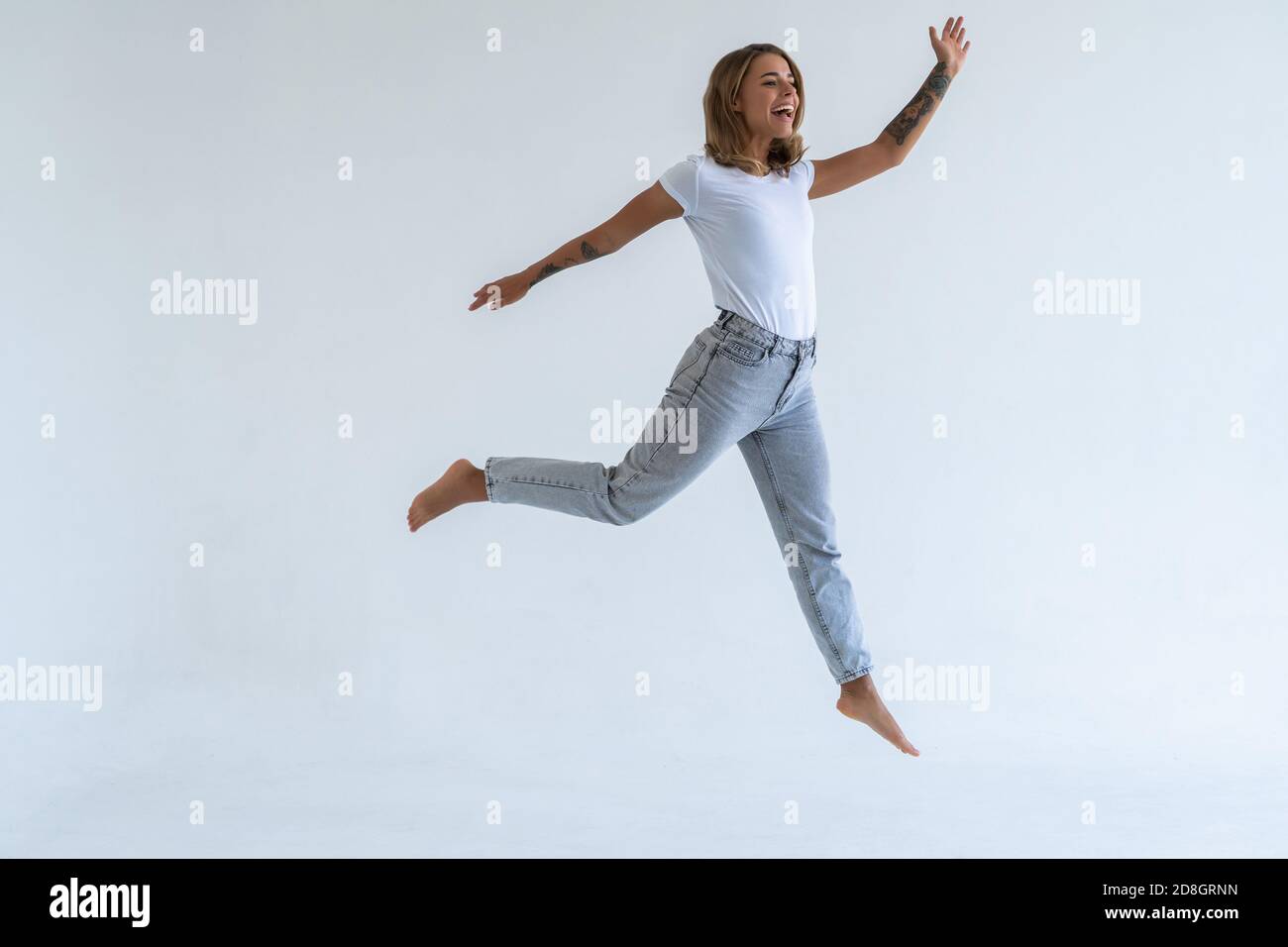 Young woman jumping happily hi-res stock photography and images - Alamy