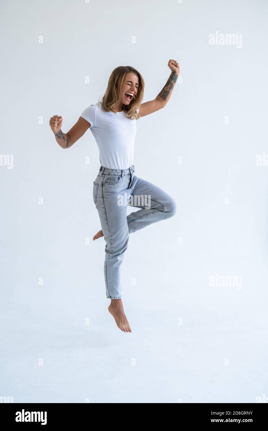 Young woman jumping isolated over white background Stock Photo - Alamy
